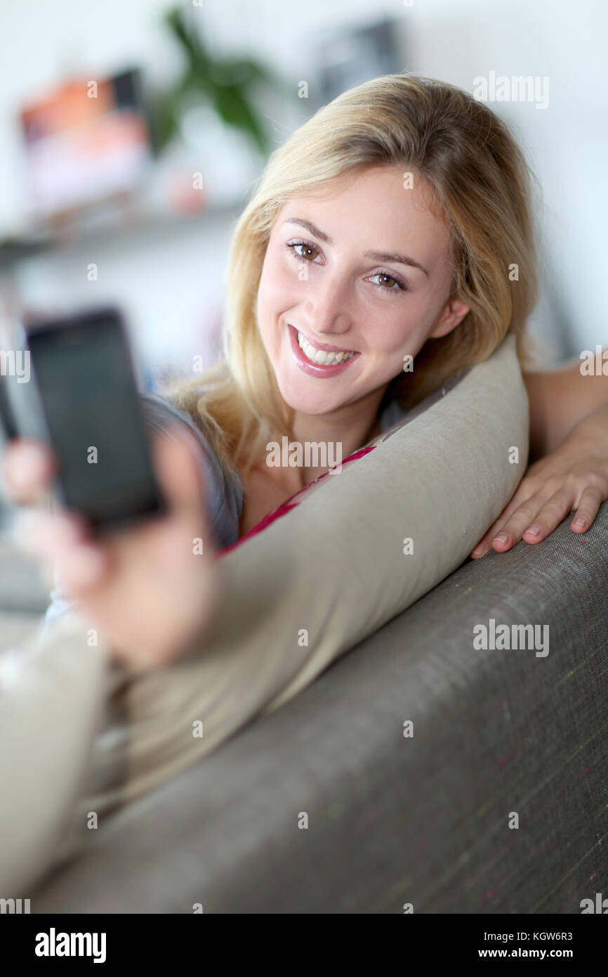 Smilng woman showing smartphone towards camera Stock Photo - Alamy