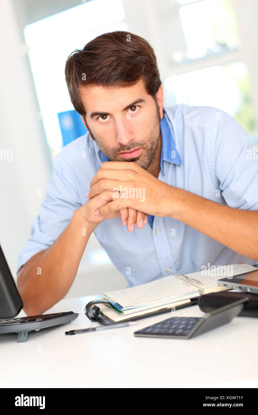 Portrait of office worker sitting at his desk Stock Photo - Alamy