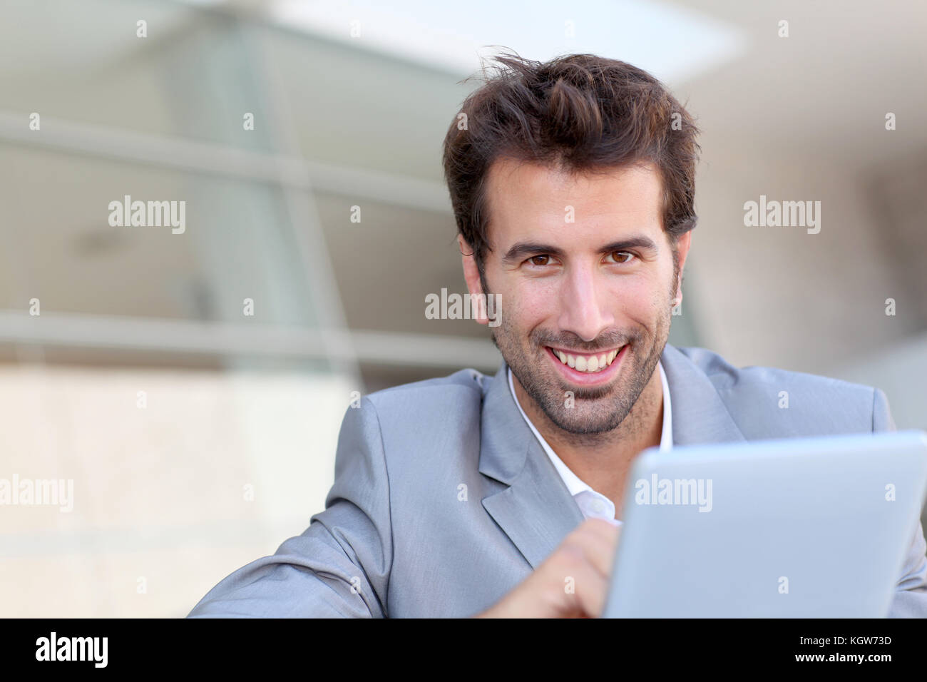 Portrait of smiling man using electronic tablet outside Stock Photo - Alamy