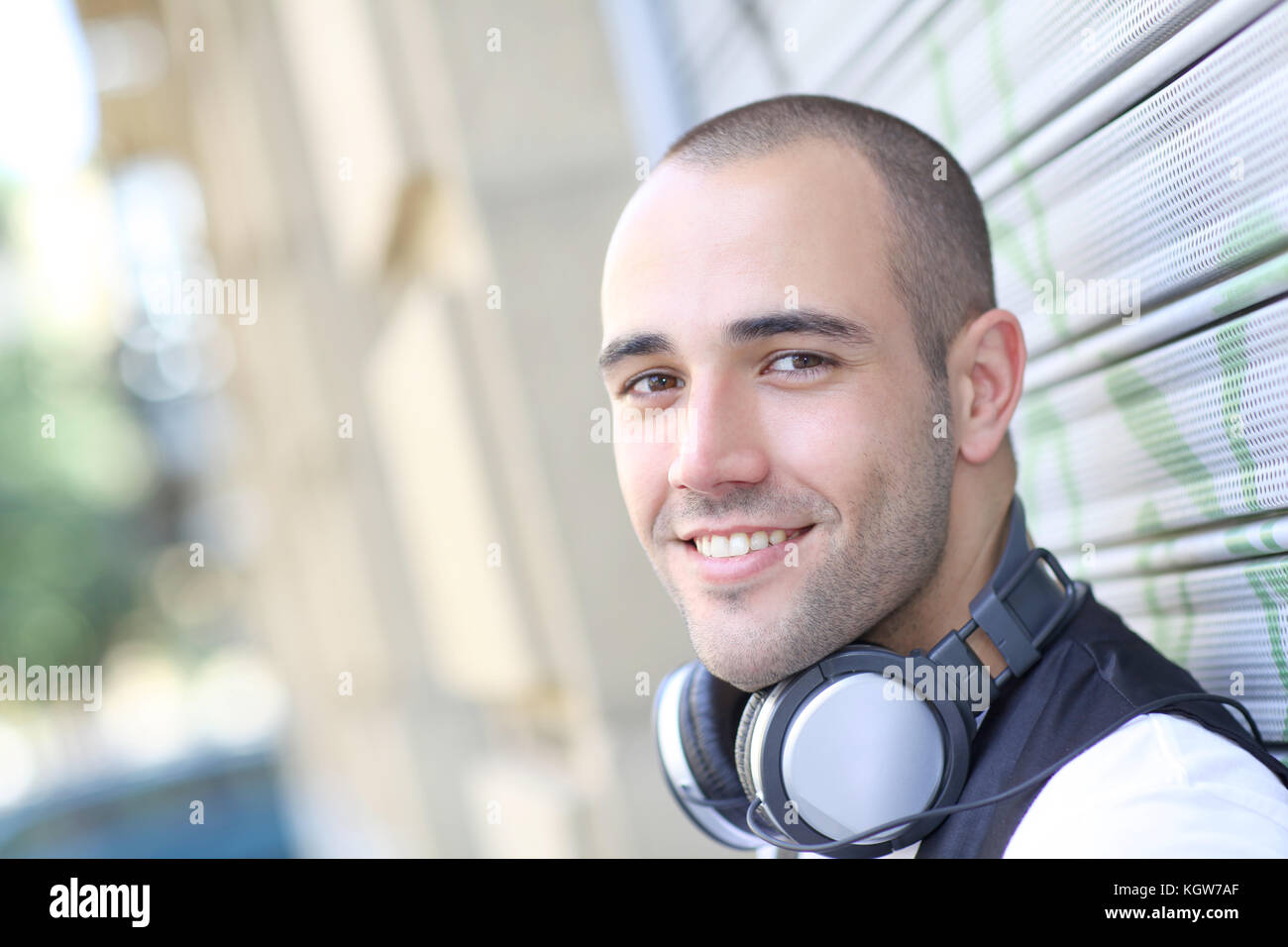 Smiling man listening to music in the street Stock Photo - Alamy