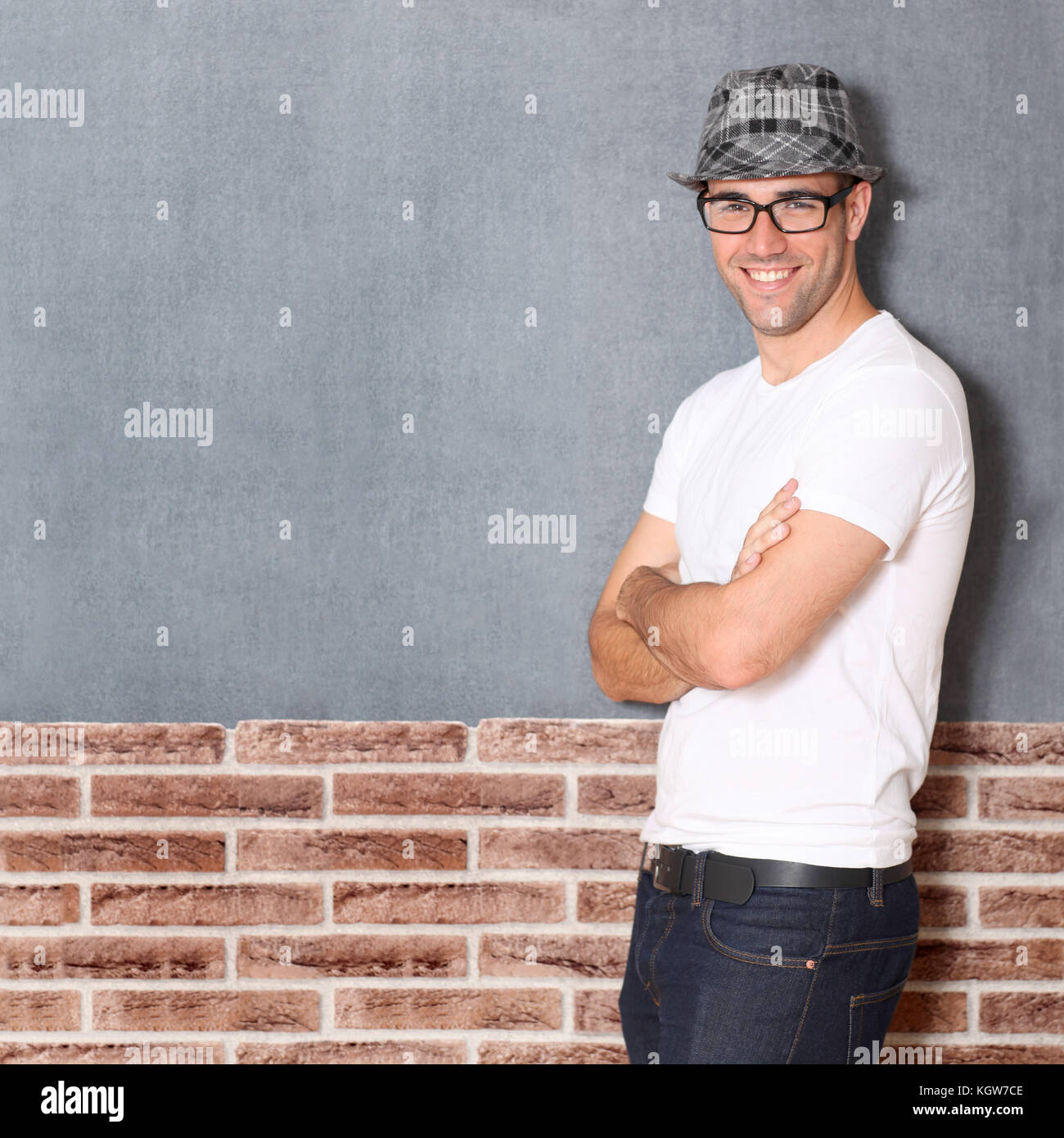Trendy guy leaning on brick wall Stock Photo - Alamy