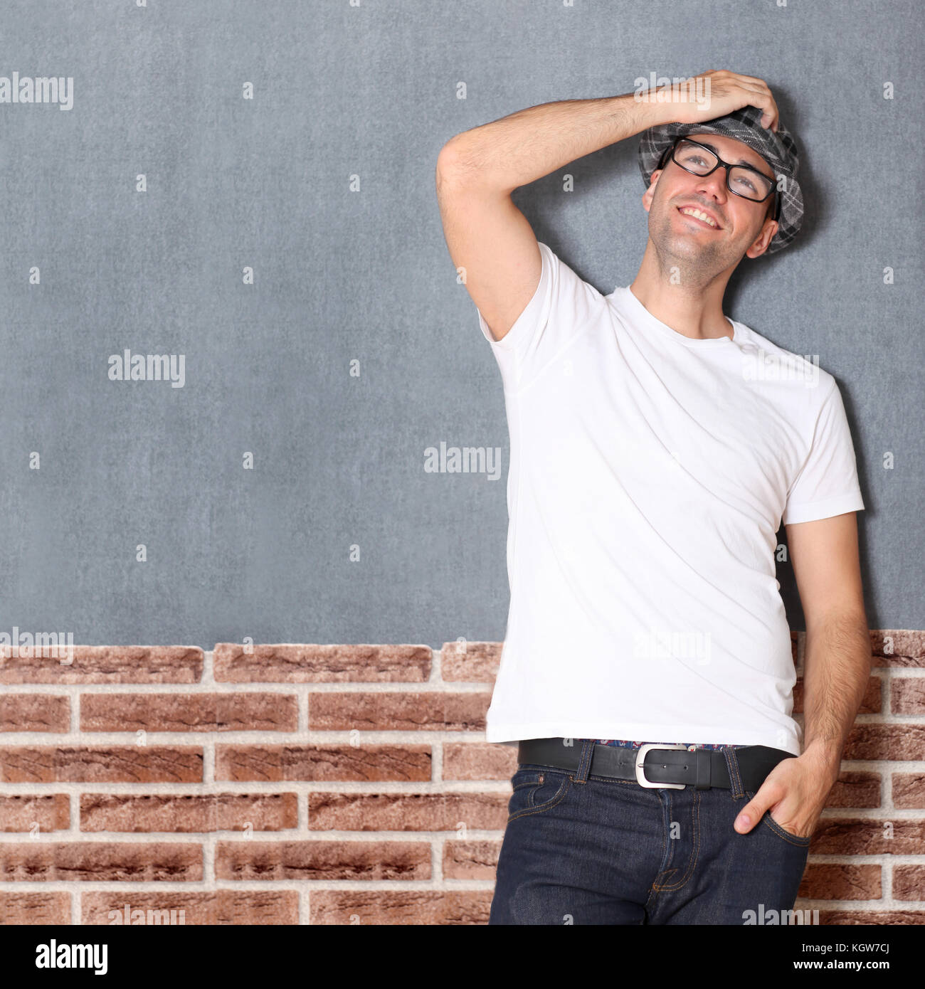 Trendy guy leaning on brick wall Stock Photo - Alamy