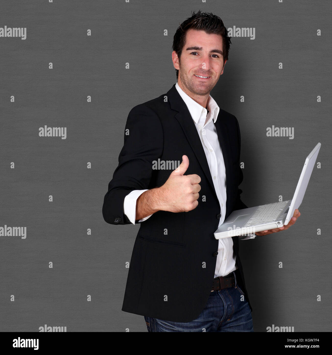 Salesman holding laptop computer and showing thumb up Stock Photo - Alamy