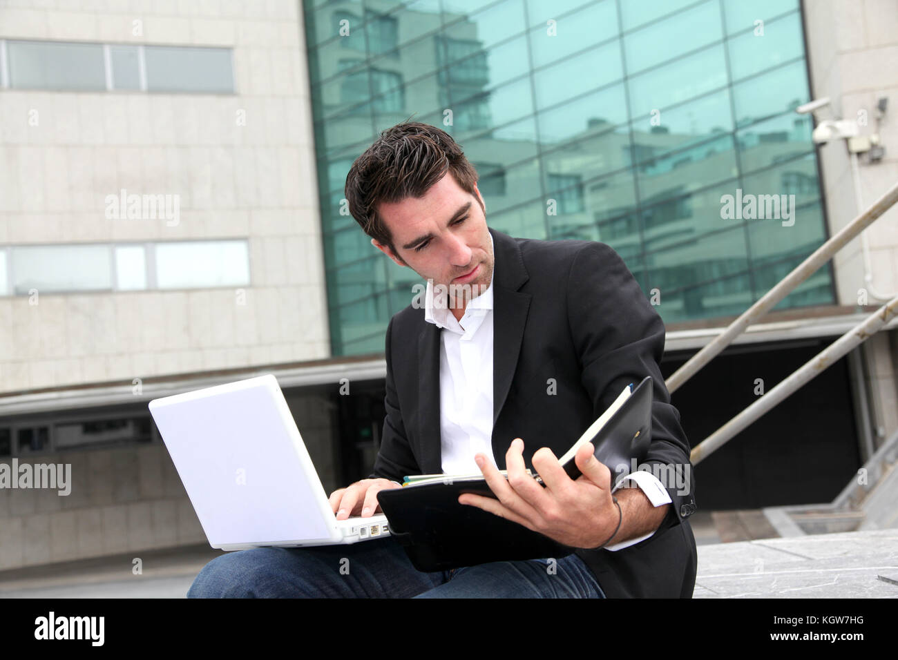 Salesman working outside building of offices Stock Photo - Alamy