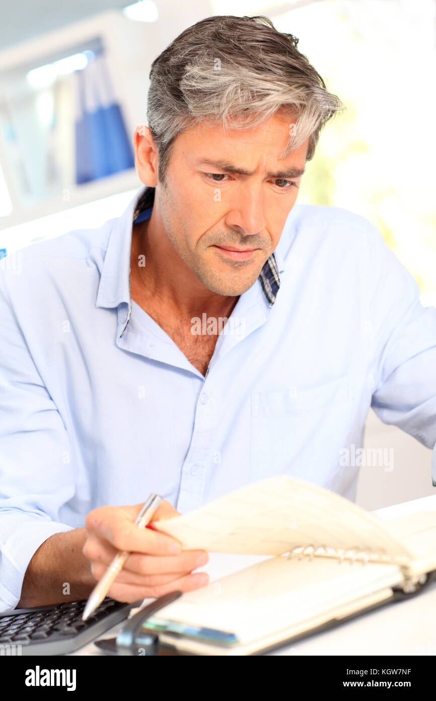 Man in office with worried look on his face Stock Photo - Alamy