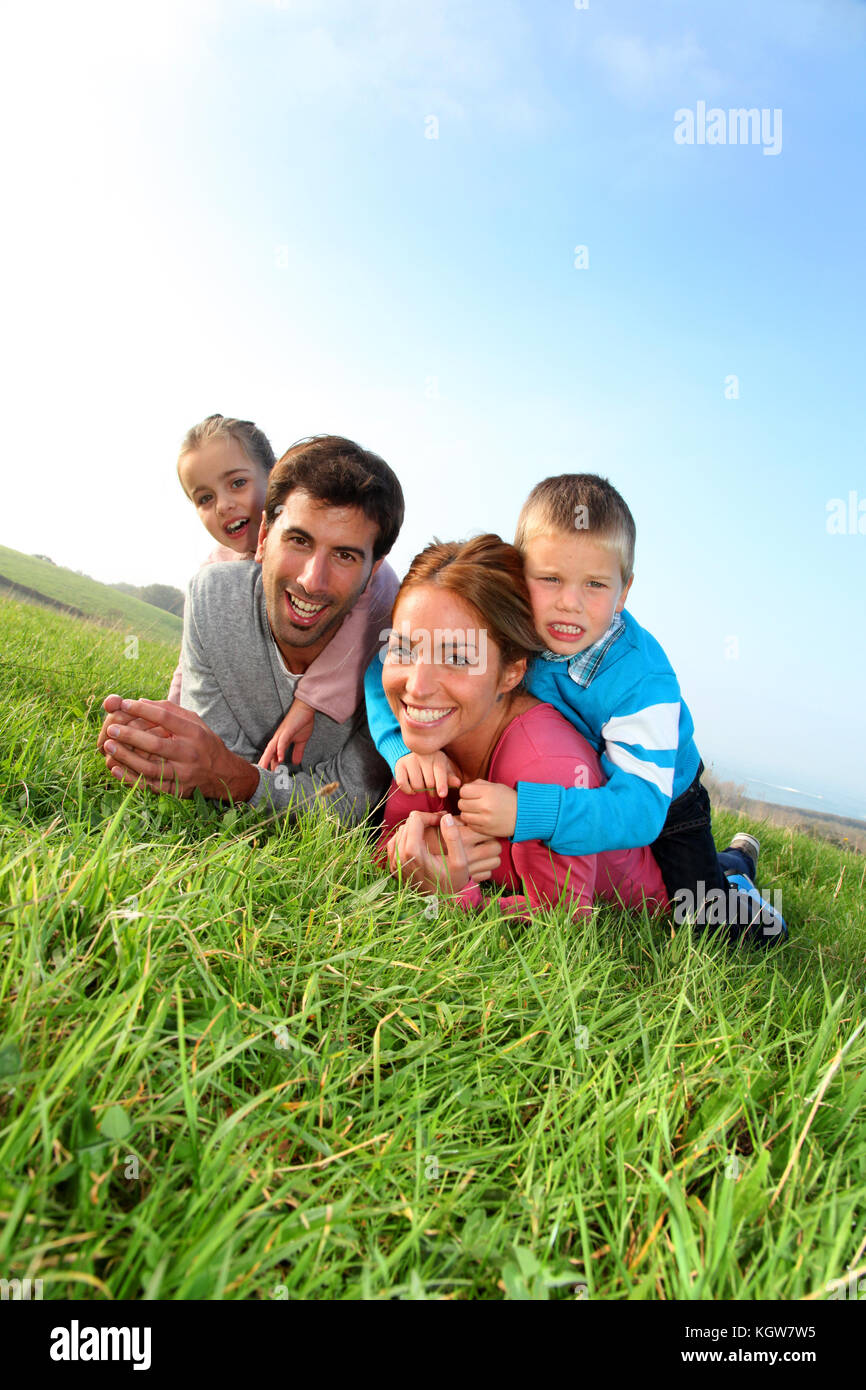 Portrait of happy family laying in country field Stock Photo - Alamy