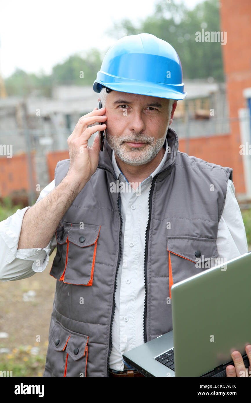 Construction manager on building site with laptop computer Stock Photo ...