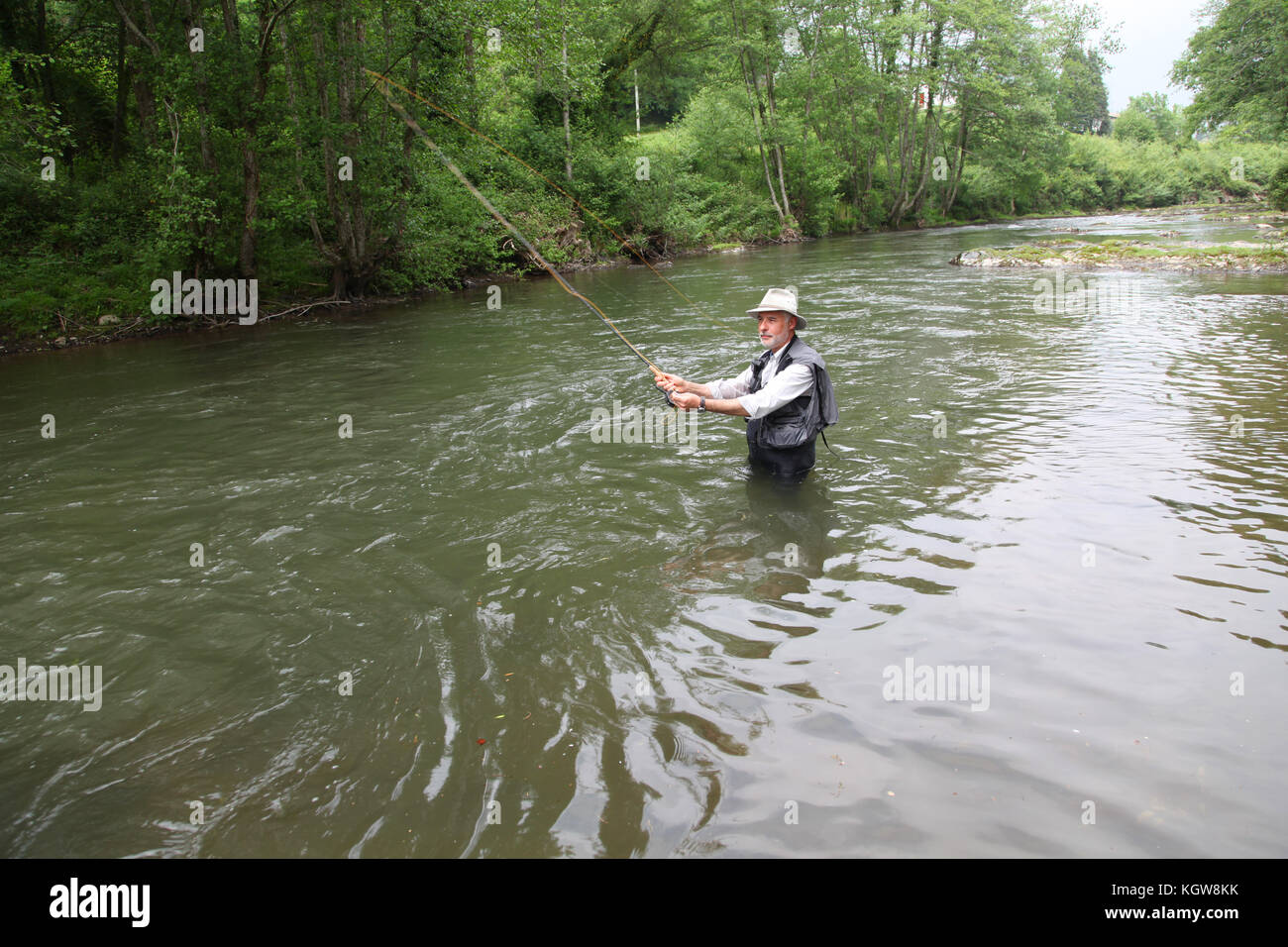 Man fishing trout in river Stock Photo - Alamy