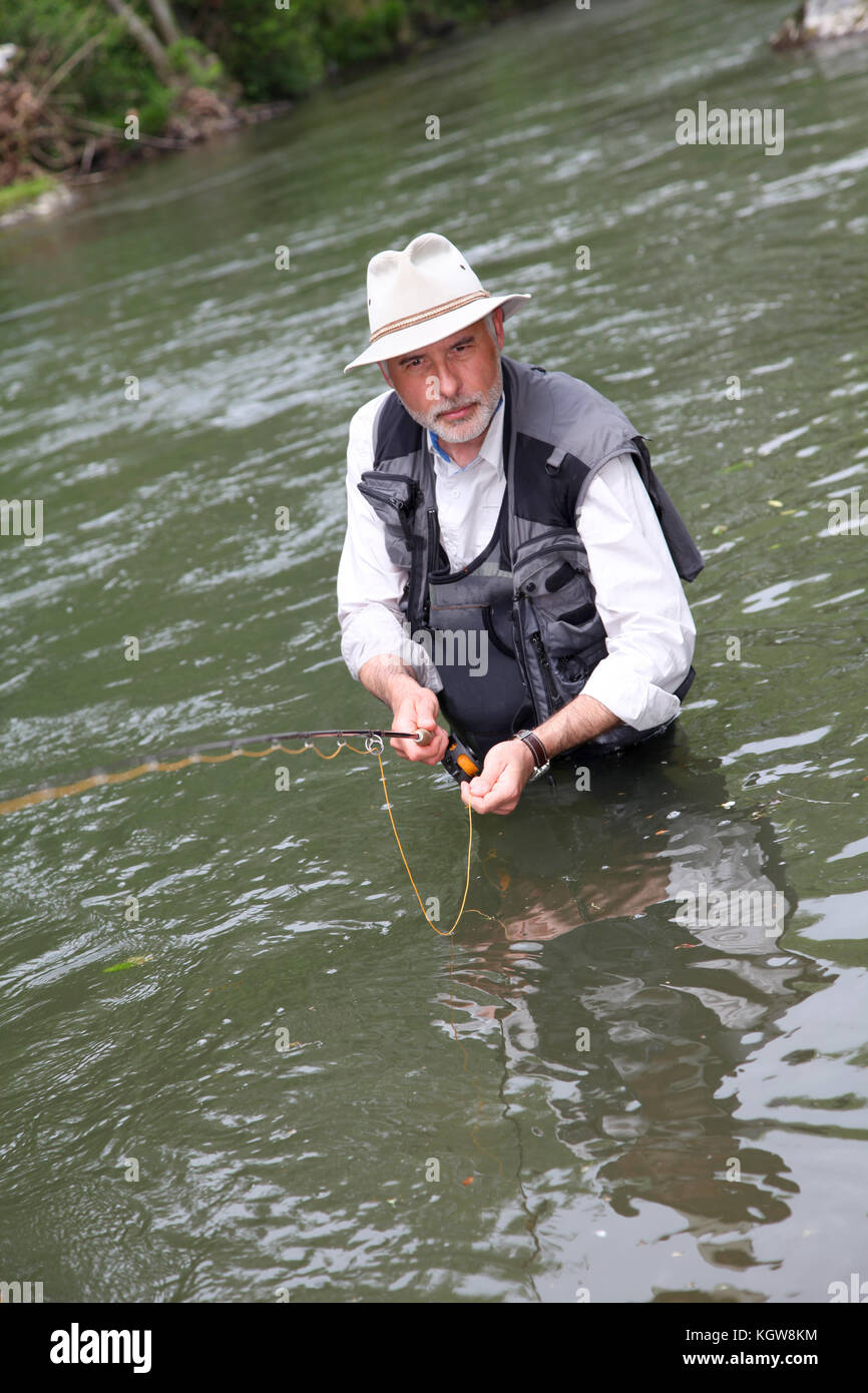 Man fishing trout in river Stock Photo - Alamy