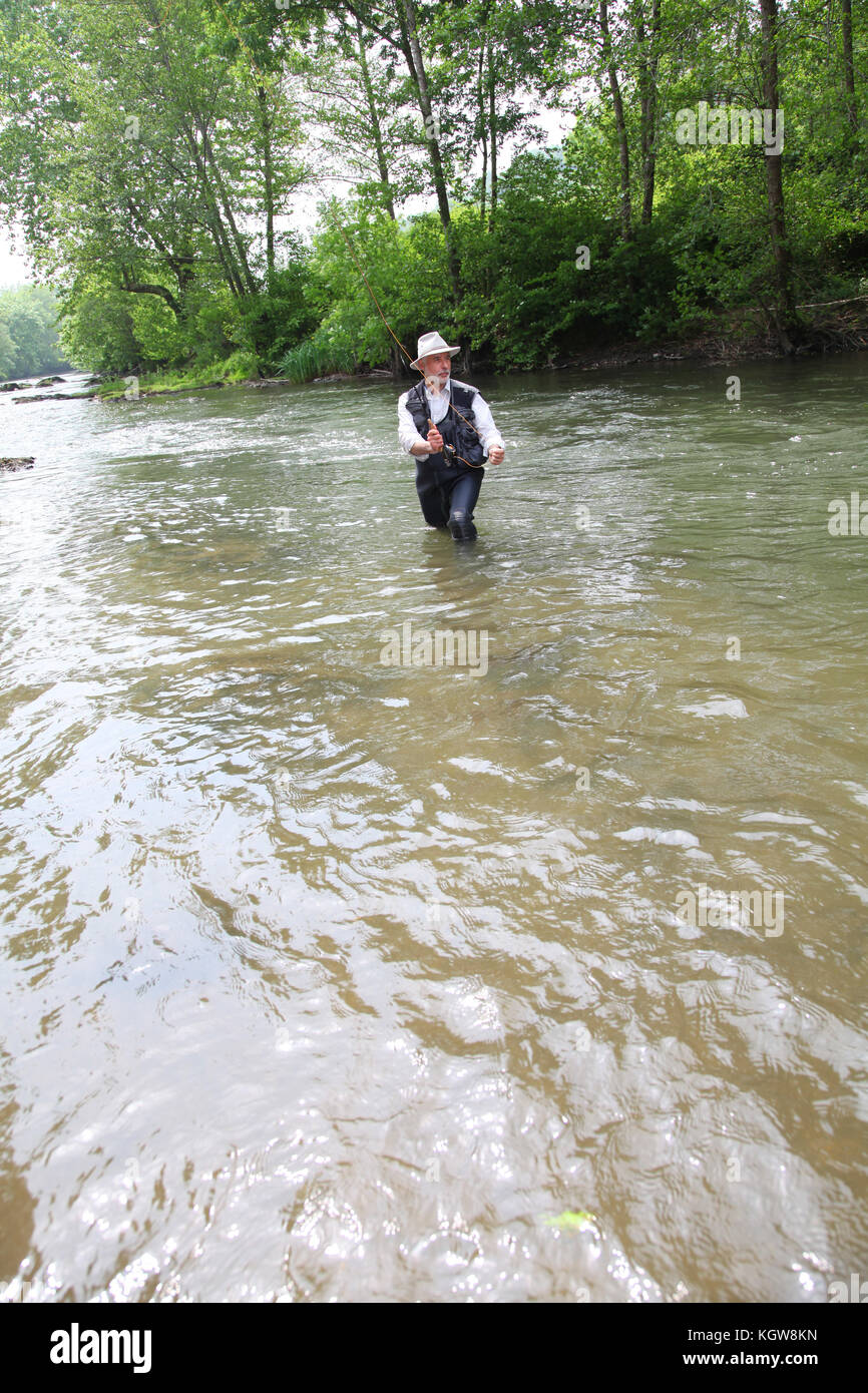 Man fishing trout in river Stock Photo - Alamy
