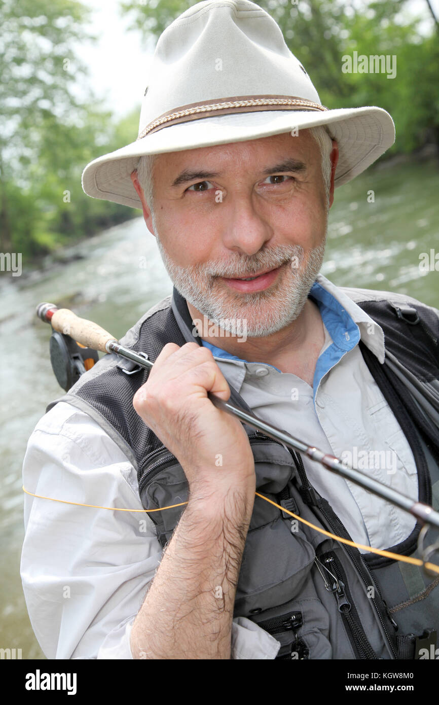 Portrait of smiling fisherman on riverside Stock Photo - Alamy