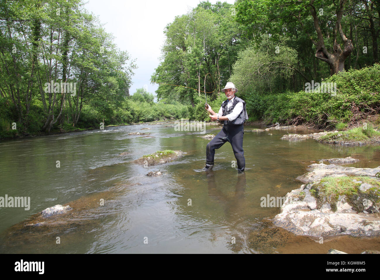 Man fishing trout in river Stock Photo - Alamy