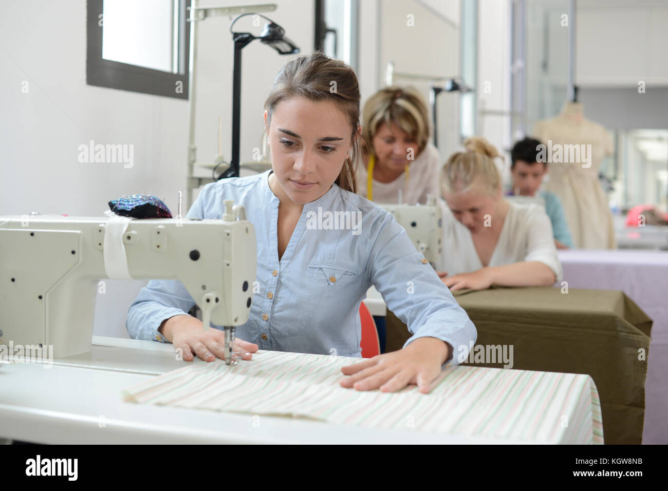 Student girl in training class working on sewing machine Stock Photo ...