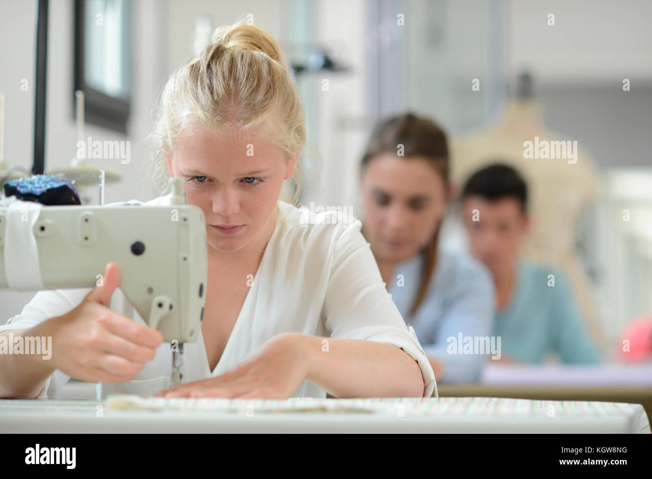 Student girl in training class working on sewing machine Stock Photo ...