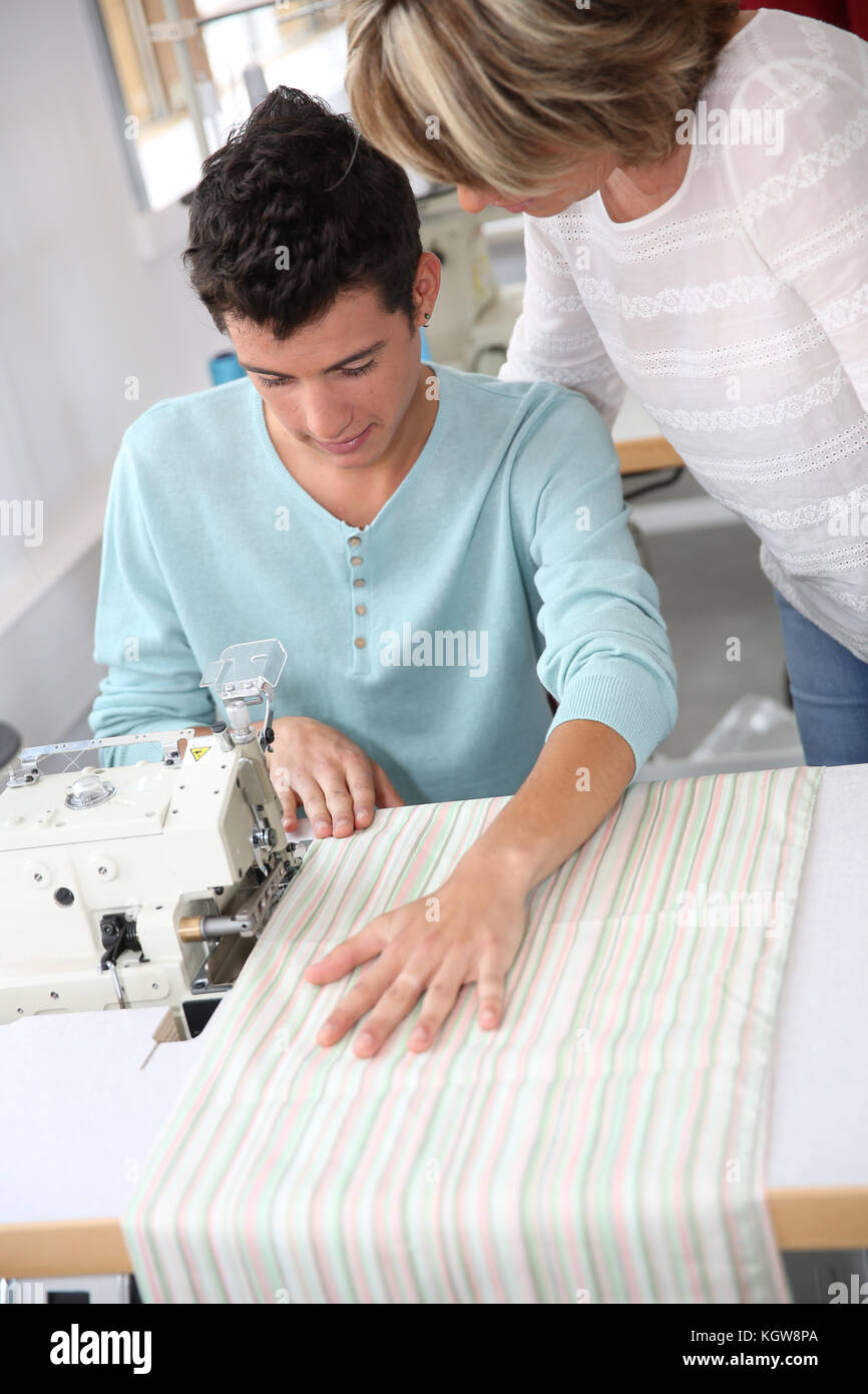 Woman in dressmaking class helping student Stock Photo - Alamy