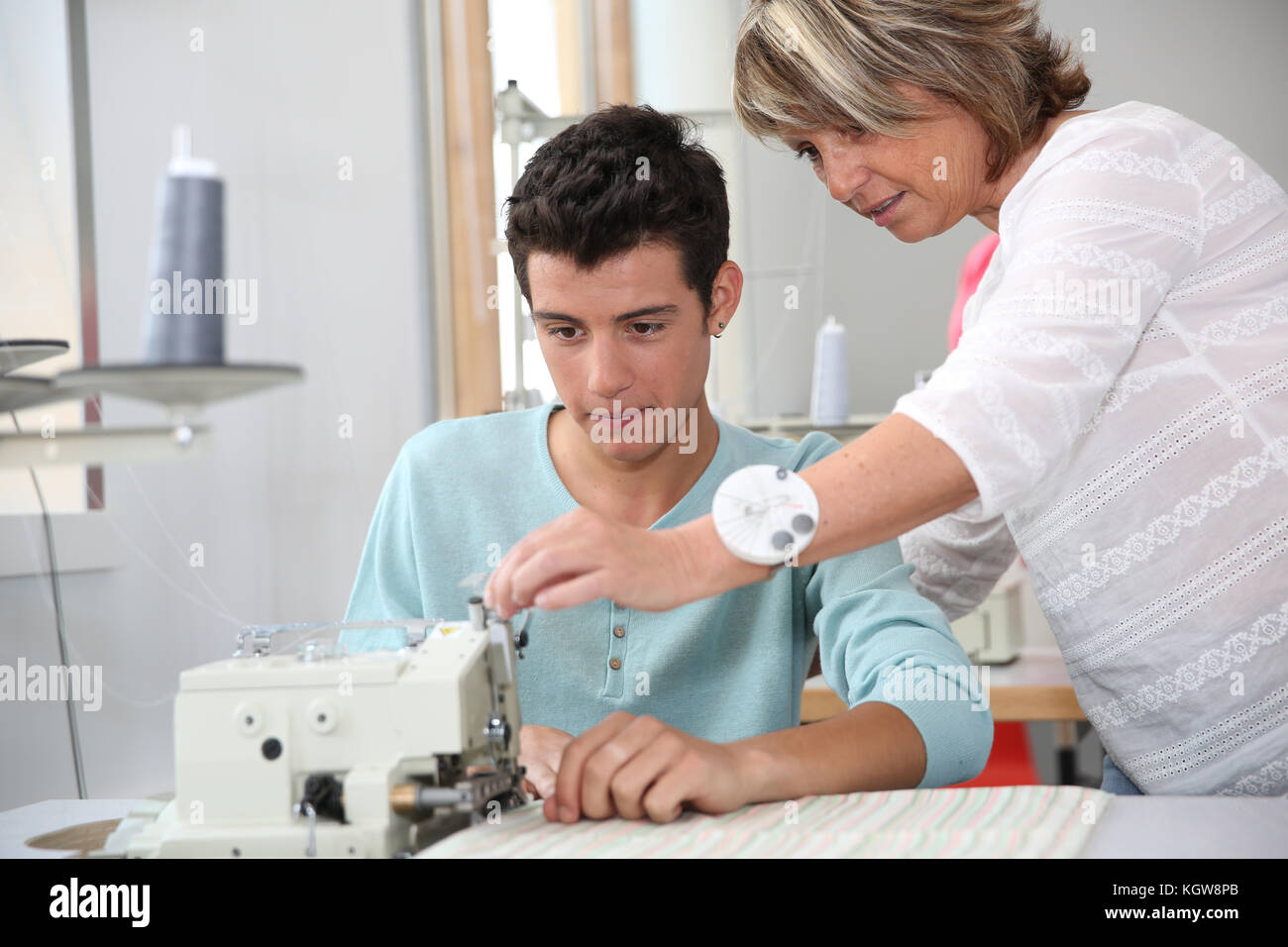 Woman in dressmaking class helping student Stock Photo - Alamy
