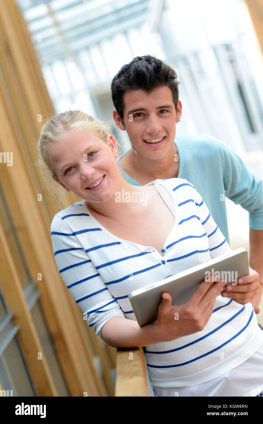 Teenagers using digital tablet at school Stock Photo - Alamy