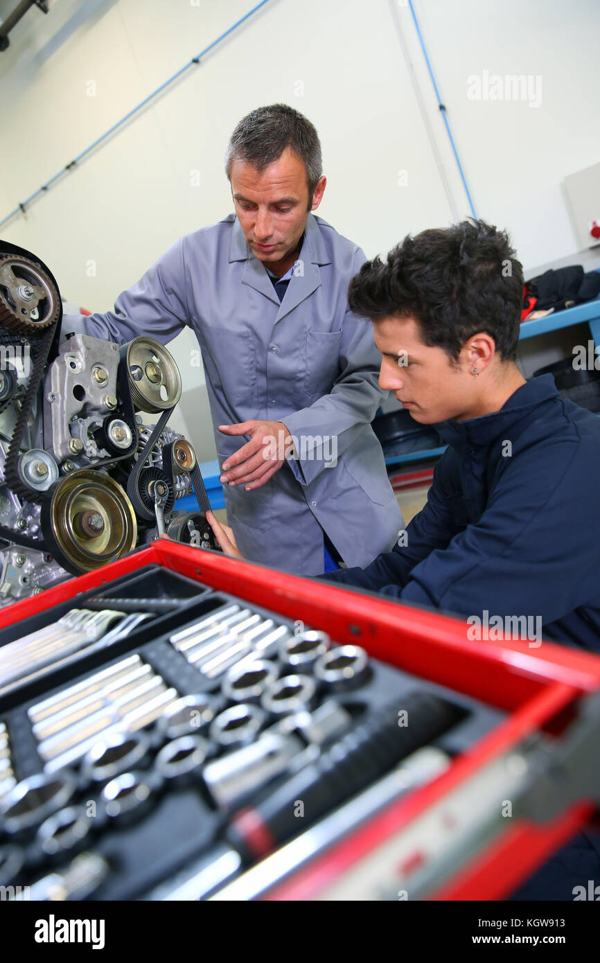 Professional trainer teaching student how to fix car engine Stock Photo ...