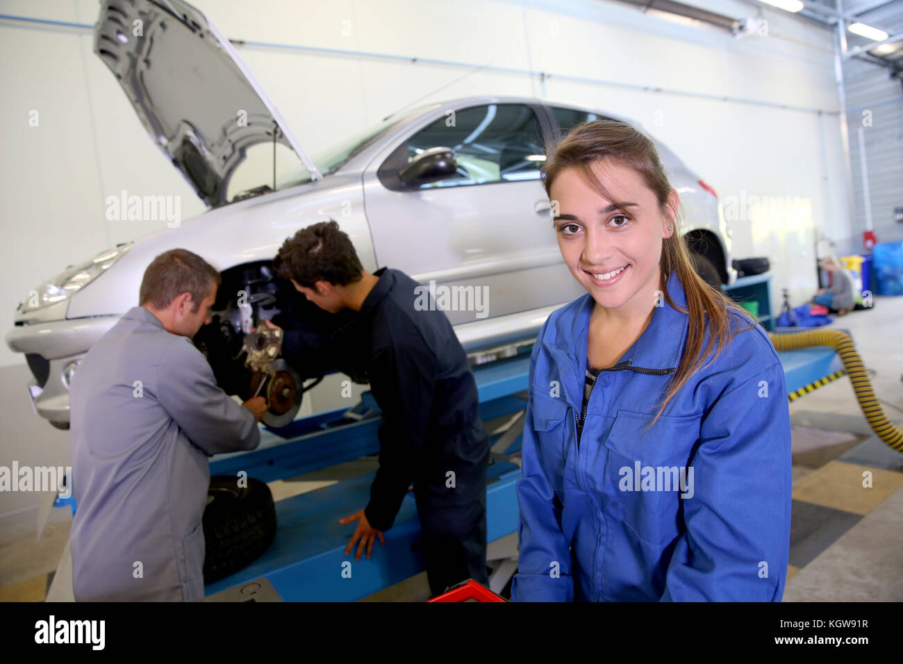 Smiling young woman in auto mechanics training class Stock Photo - Alamy