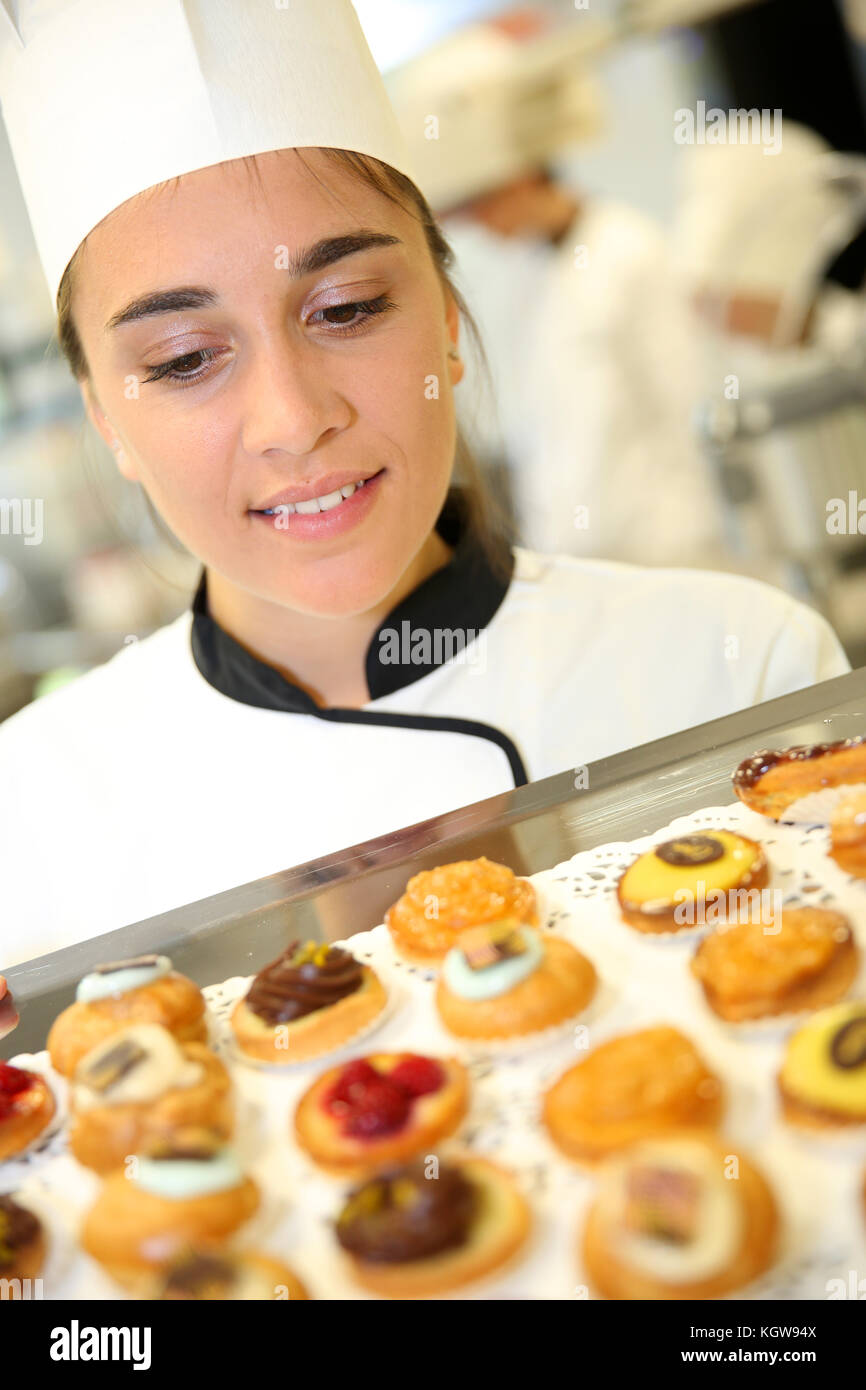 Cheerful pastry cook holding tray of pastries Stock Photo - Alamy