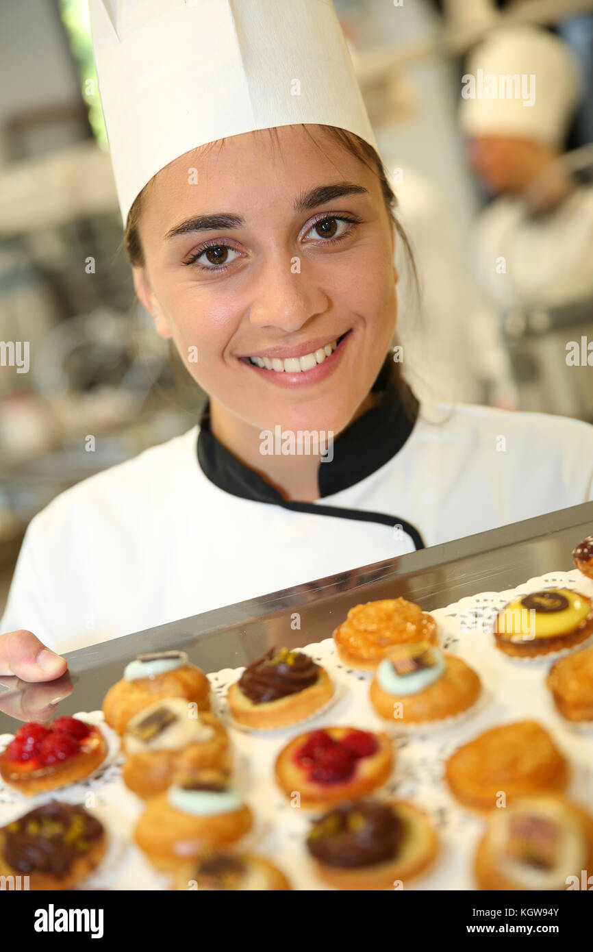 Cheerful pastry cook holding tray of pastries Stock Photo - Alamy