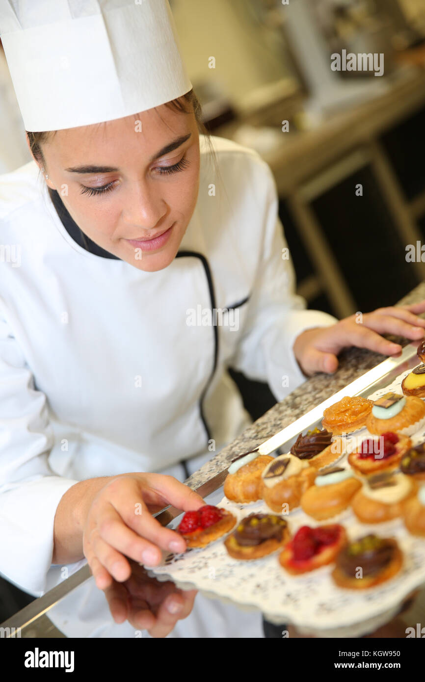 Cheerful pastry cook holding tray of pastries Stock Photo - Alamy