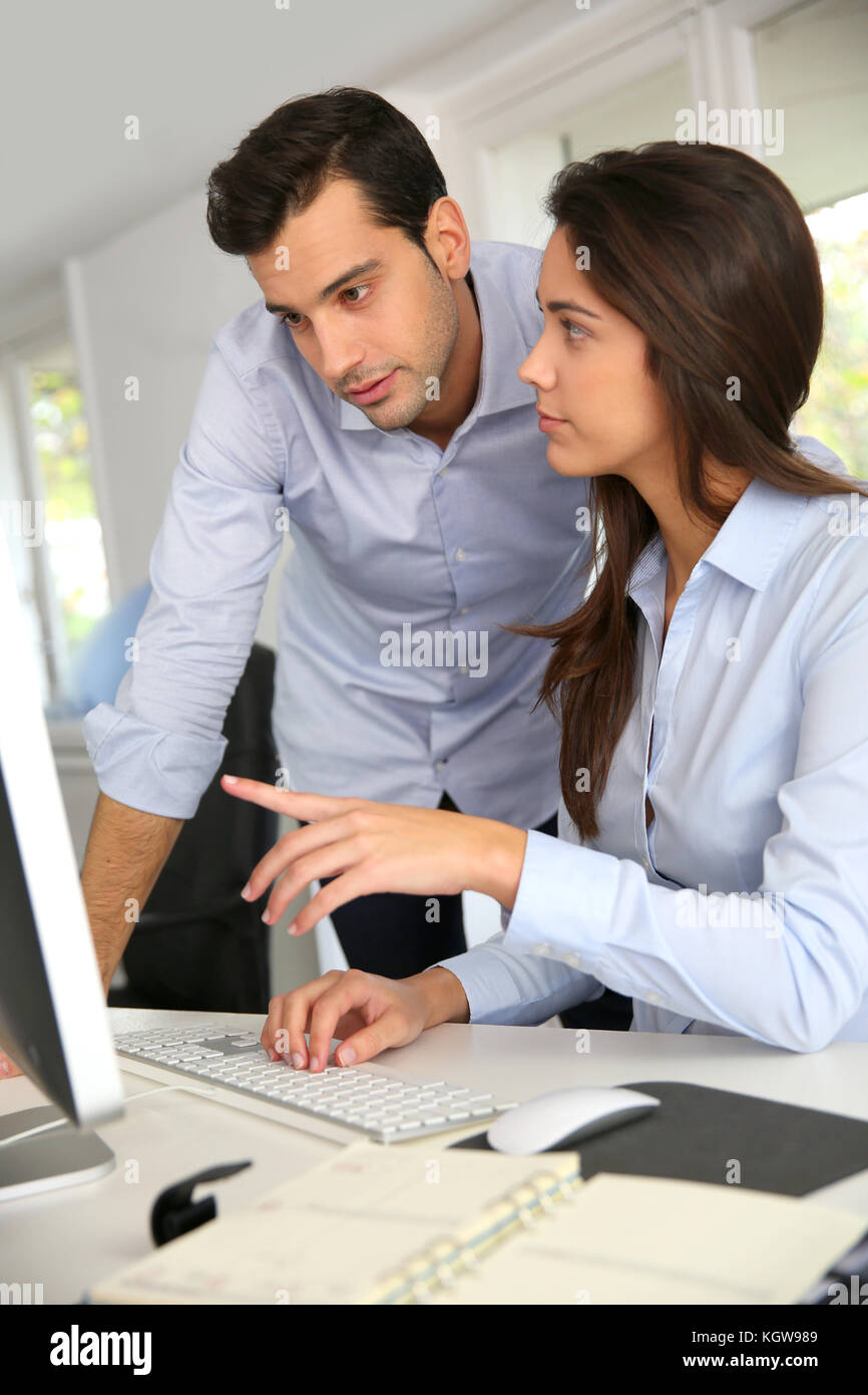 Young office workers in front of desktop computer Stock Photo - Alamy