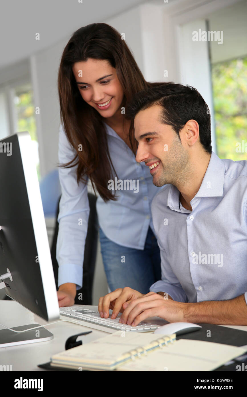Young office workers in front of desktop computer Stock Photo - Alamy