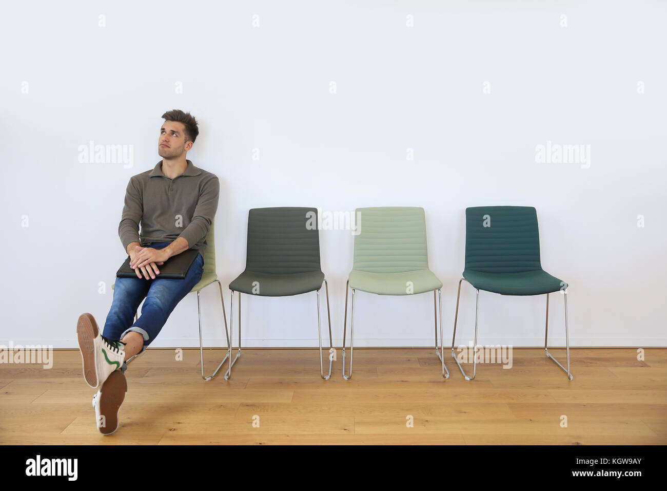 Young man in waiting room for job interview Stock Photo - Alamy