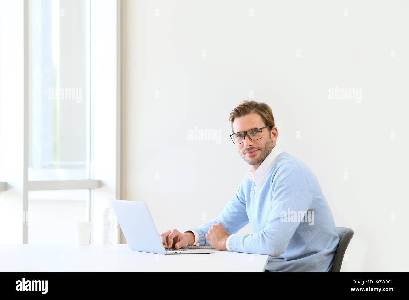 Businessman in modern office working on laptop Stock Photo - Alamy