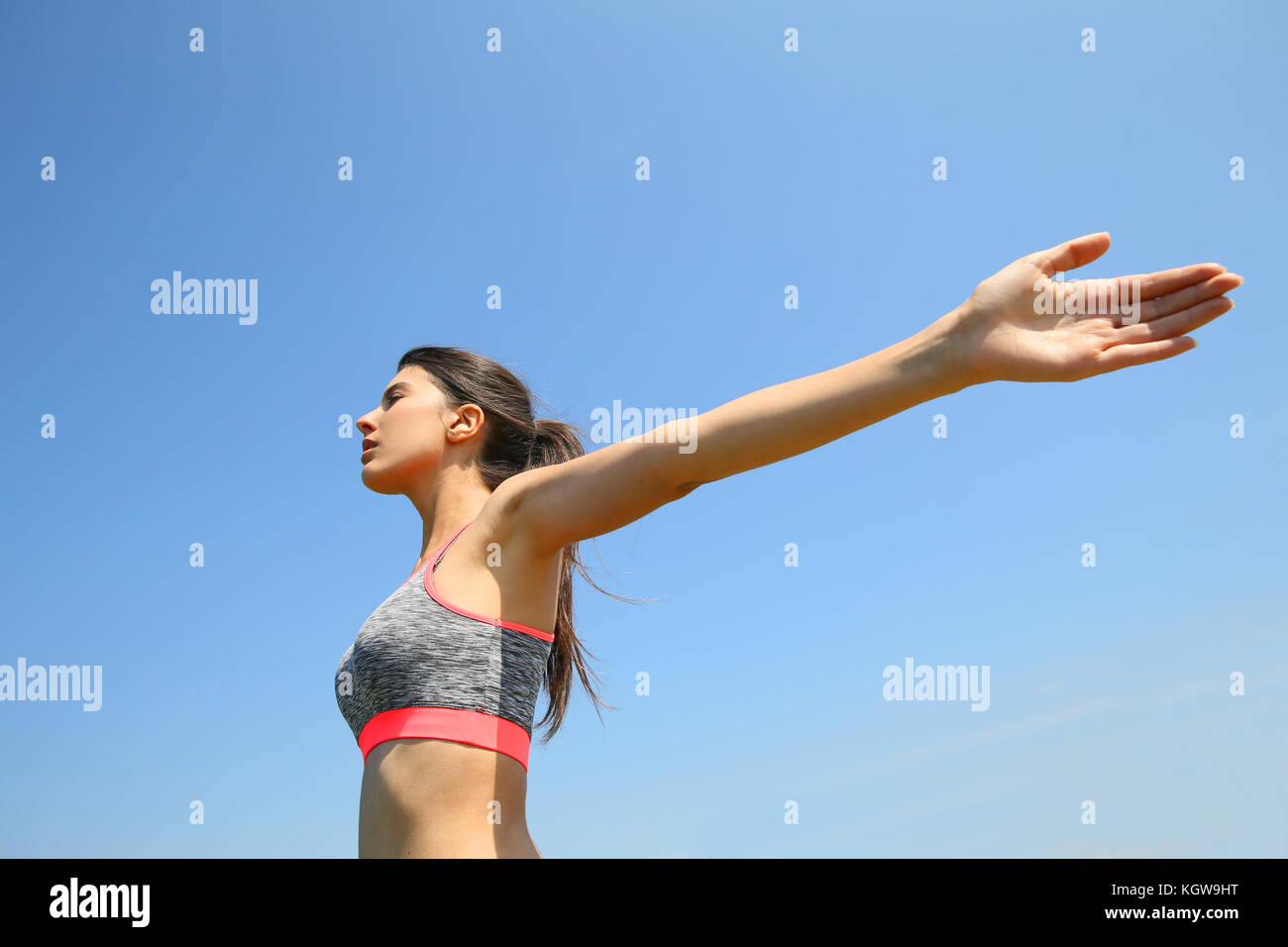 Brunette fitness girl stretching arms out by the sea Stock Photo - Alamy