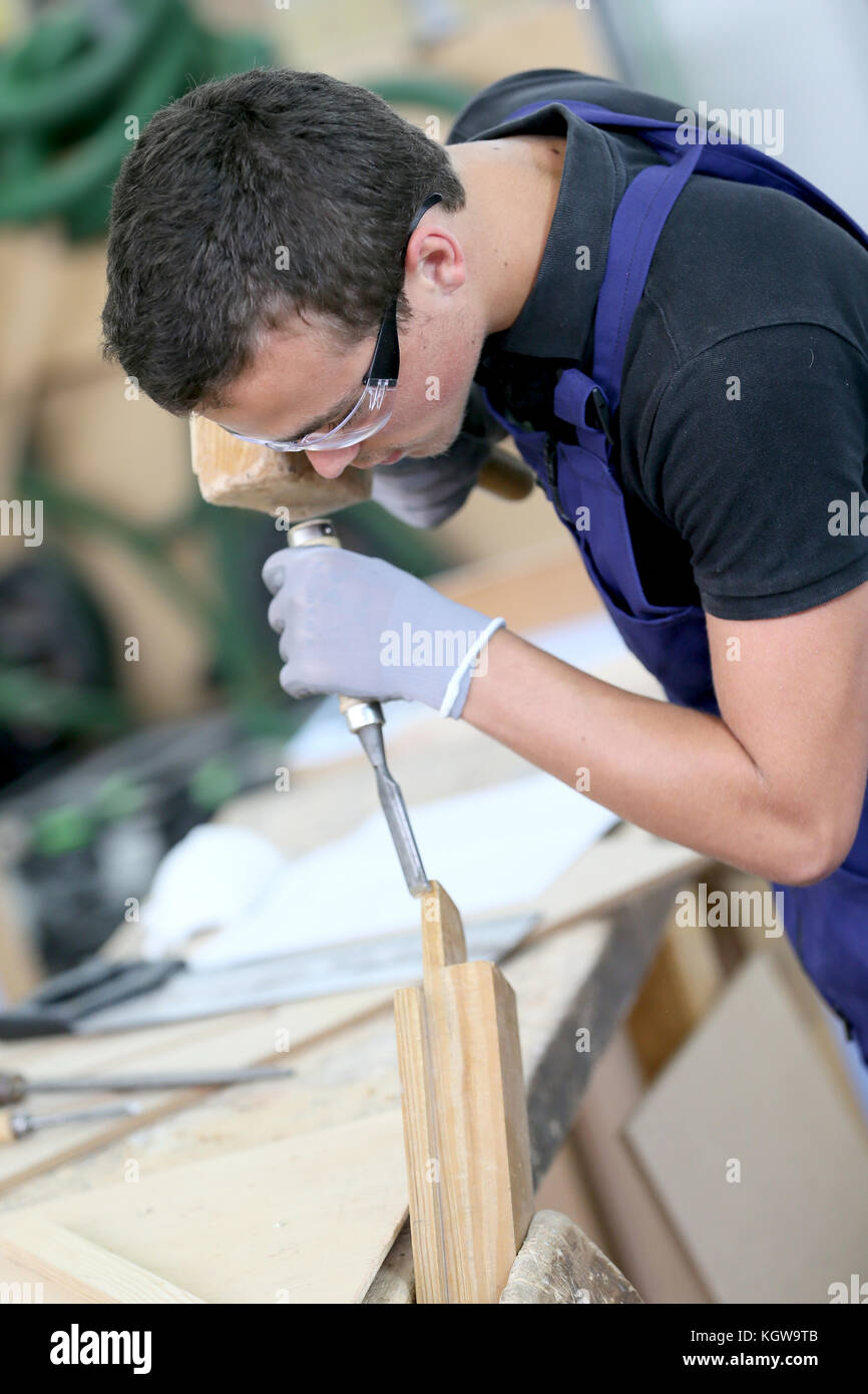 Young apprentice in carpentry working piece of wood Stock Photo - Alamy