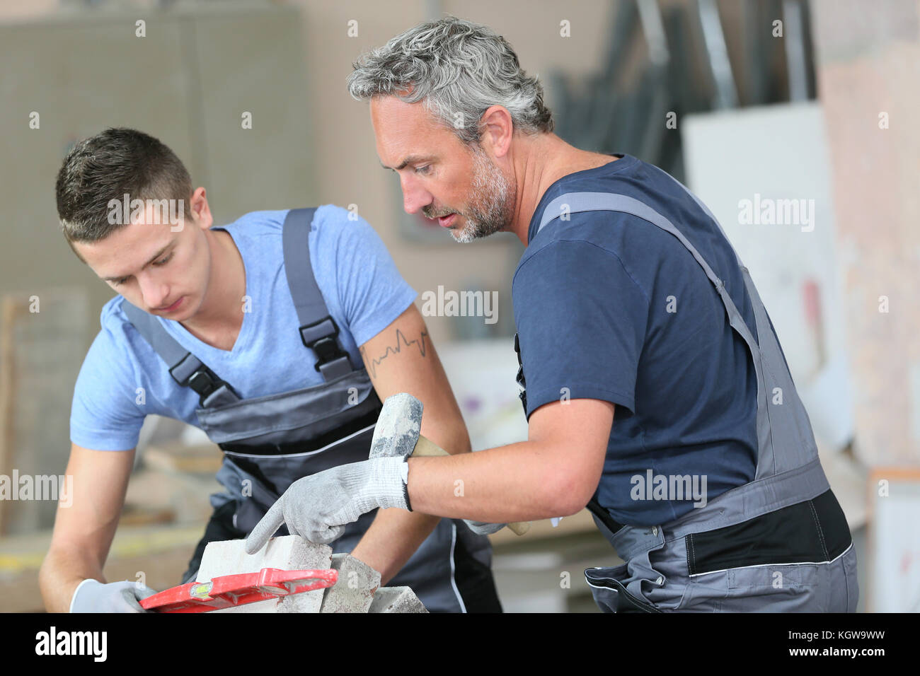 Teenager with professional brick layer in training school Stock Photo ...