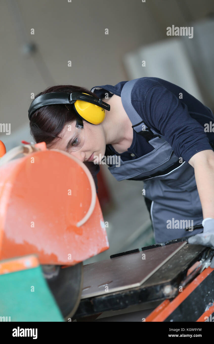 Young woman in professional training using tile grinder Stock Photo - Alamy