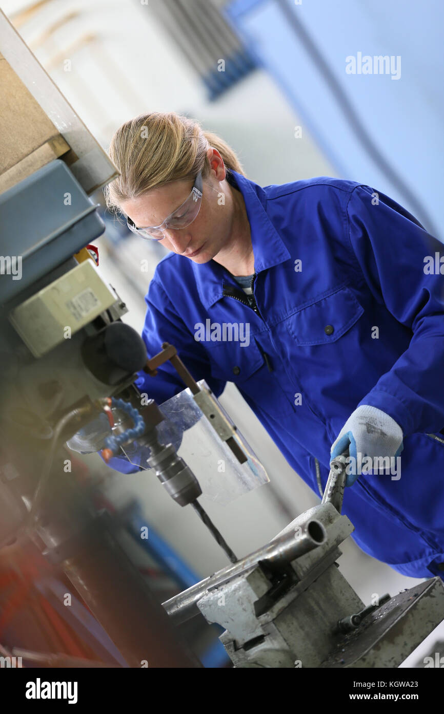 Metalworker making holes in steel tubes with machine Stock Photo - Alamy