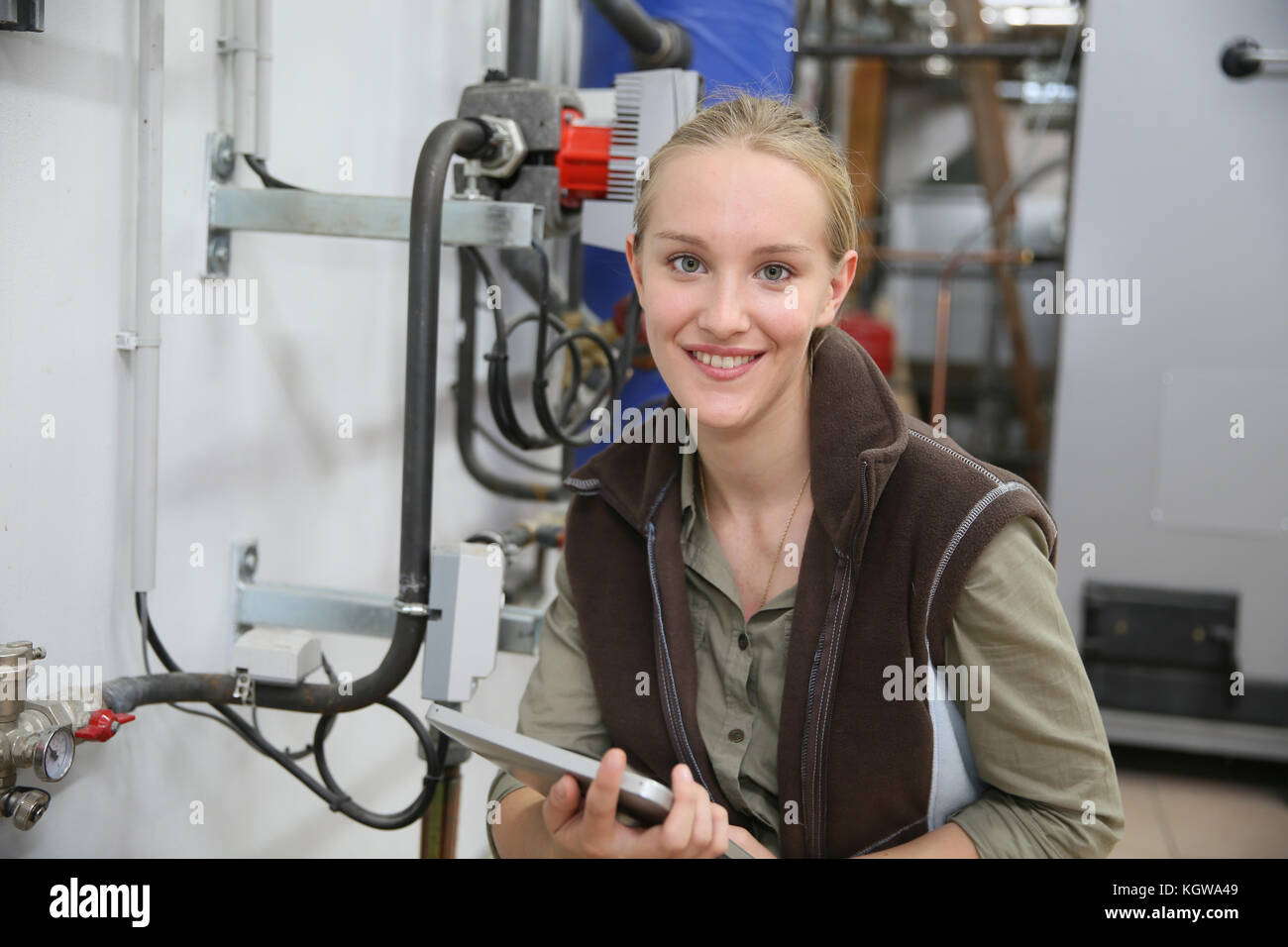 Young woman controlling water level in machinery Stock Photo - Alamy