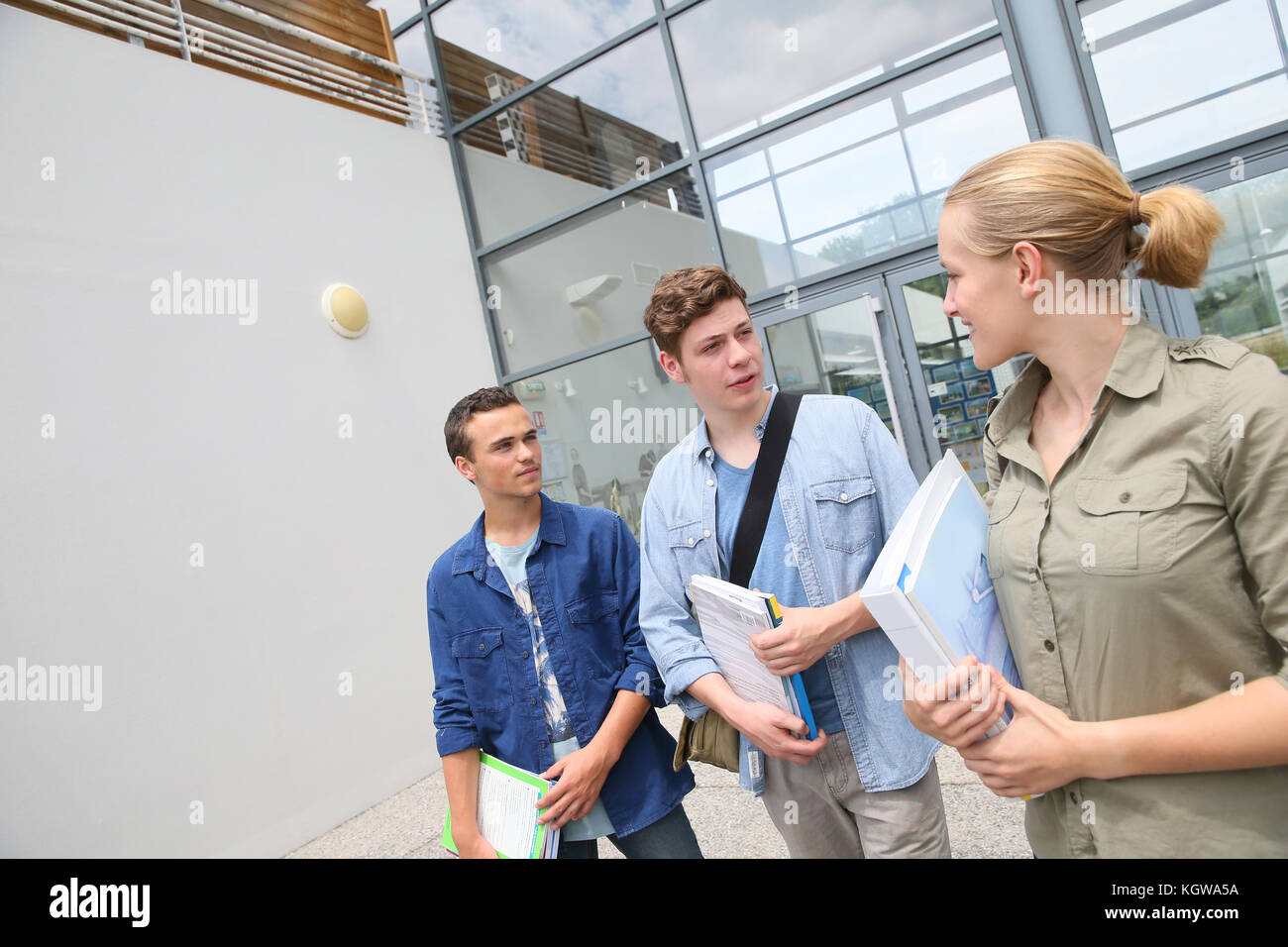 Young students walking outside campus building Stock Photo - Alamy