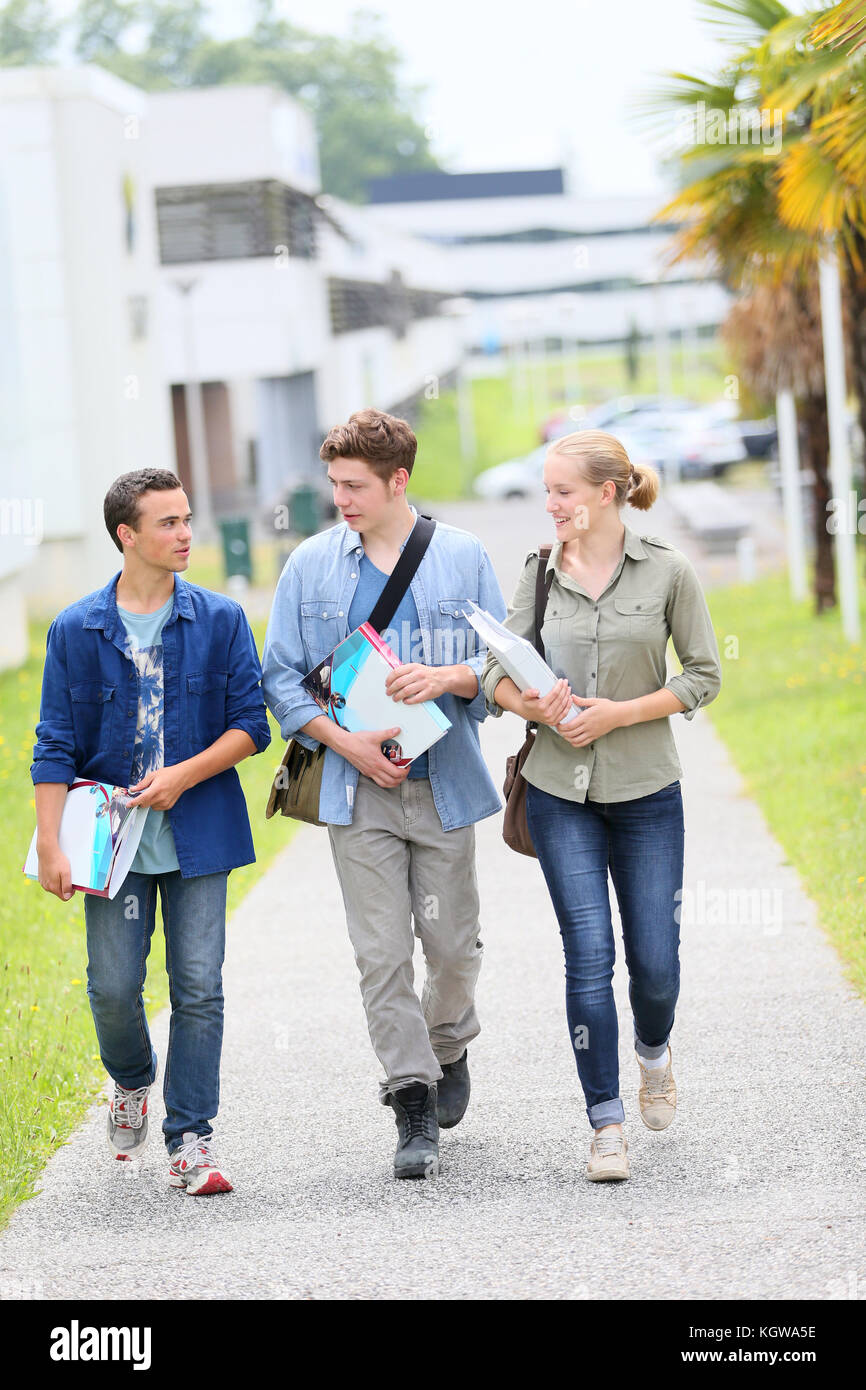 Young students walking outside campus building Stock Photo - Alamy