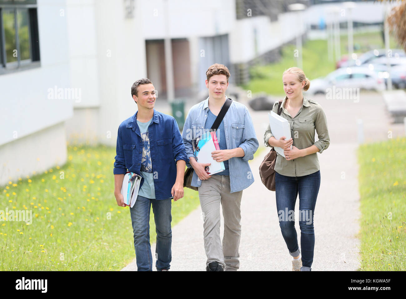 Young students walking outside campus building Stock Photo - Alamy