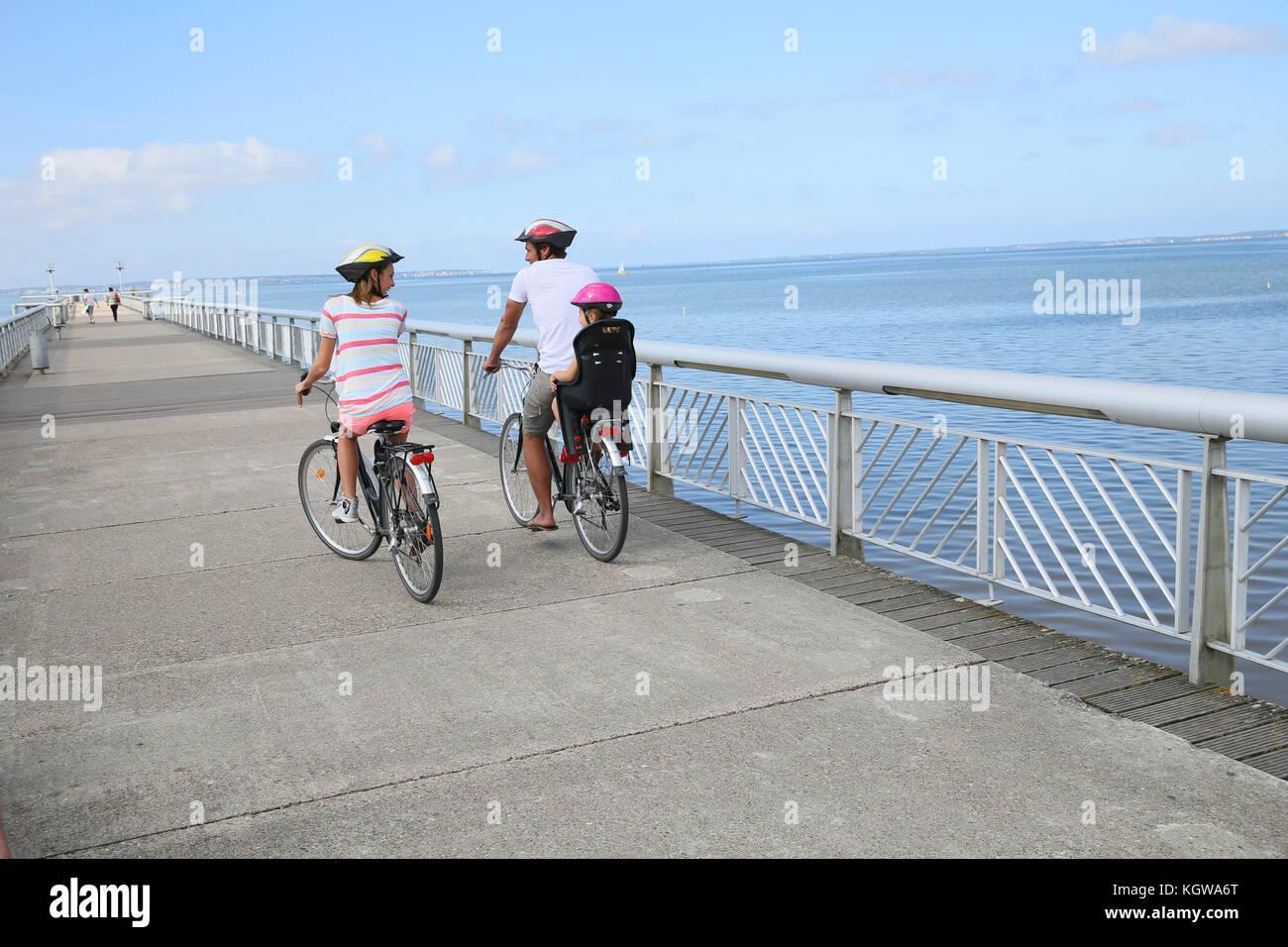 Back view of family on a biking journey by the sea Stock Photo - Alamy