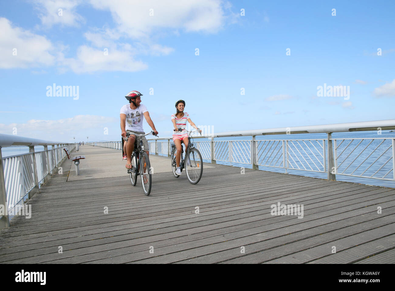 Couple with kid riding bicycle on a pontoon Stock Photo - Alamy
