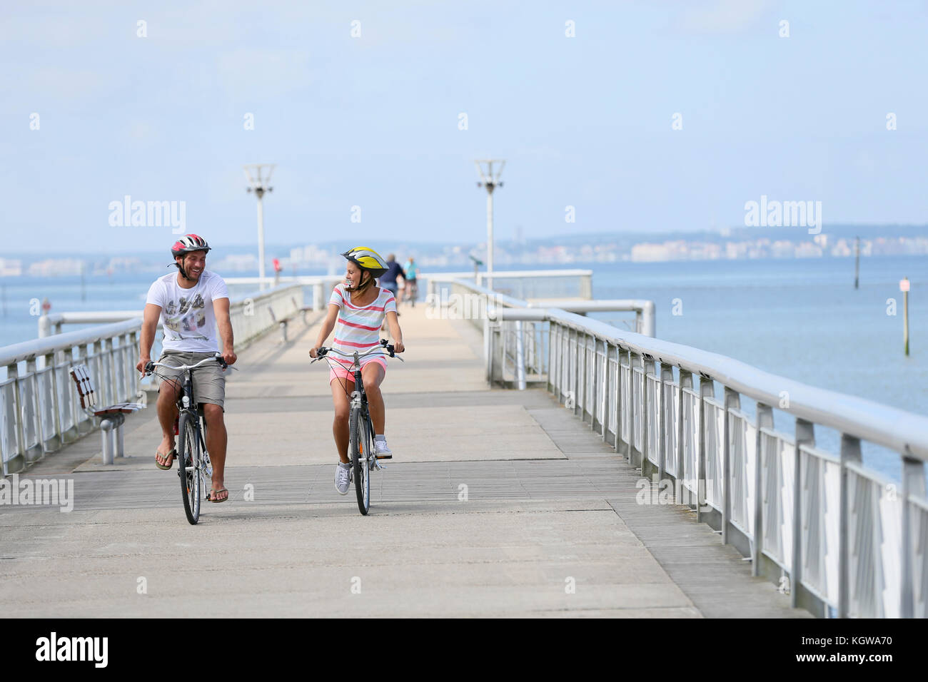 Couple with kid riding bicycle on a pontoon Stock Photo - Alamy