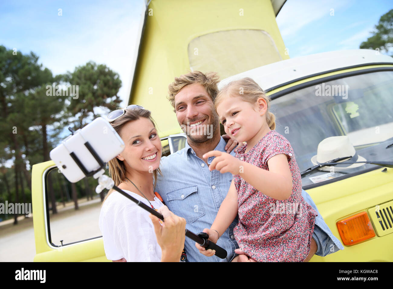 Family standing in front of camper van taking selfie picture Stock ...