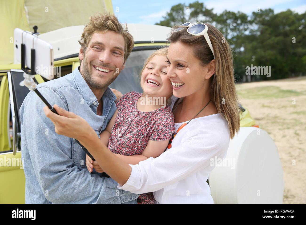 Family standing in front of camper van taking selfie picture Stock ...