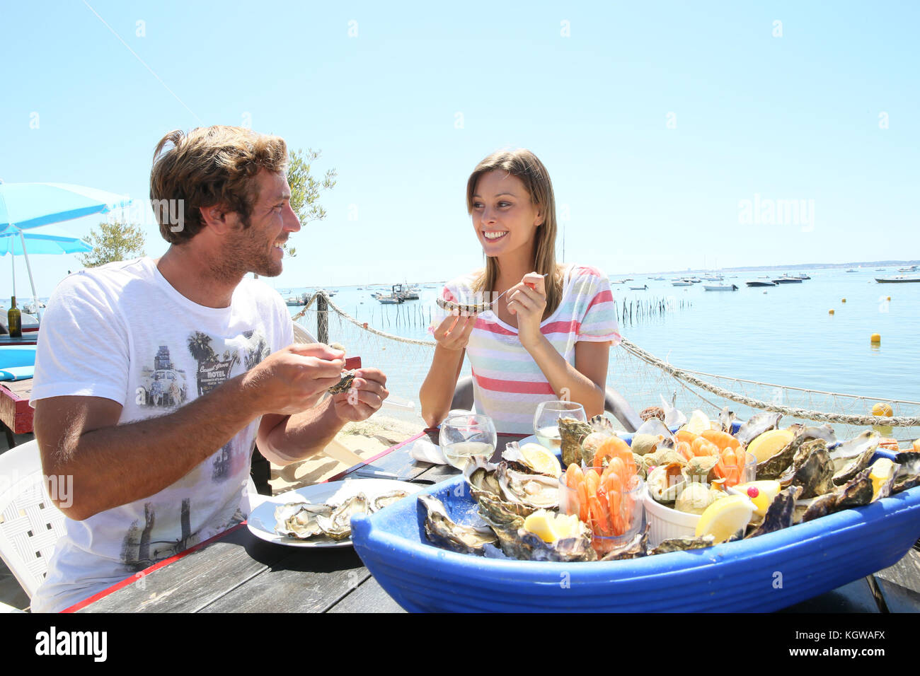Couple in seafood restaurant tasting fresh oysters Stock Photo - Alamy