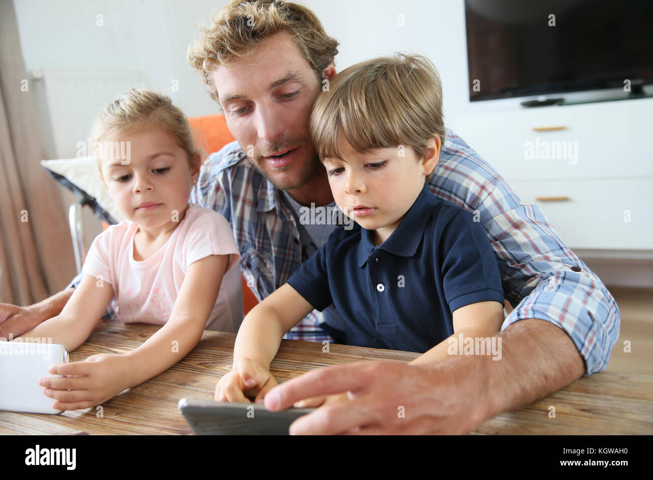 Daddy with kids playing with smartphone Stock Photo - Alamy