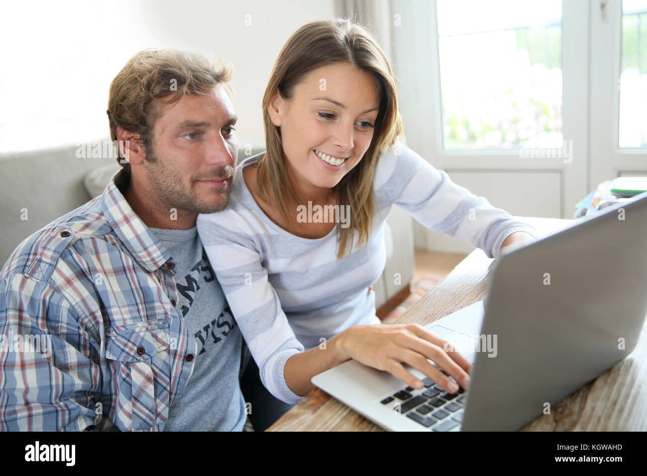 Couple connected on internet with laptop computer at home Stock Photo ...