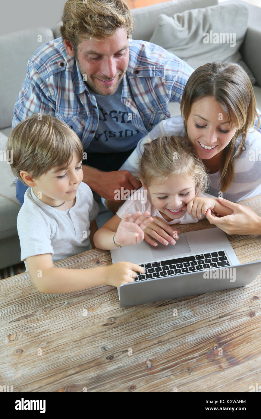 Parents with kids at home using laptop computer Stock Photo - Alamy