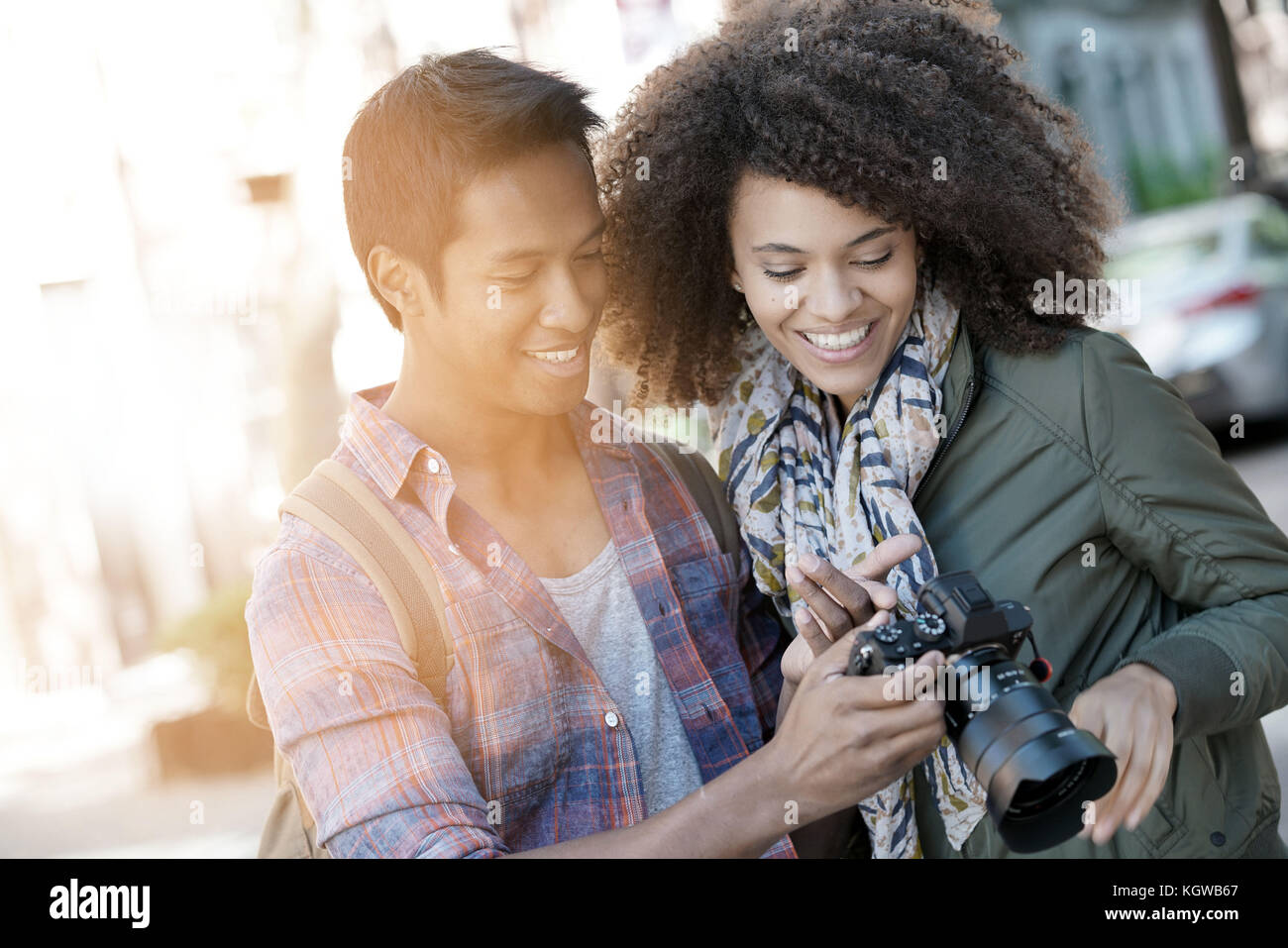 Man showing pictures to girlfriend on camera screen Stock Photo - Alamy