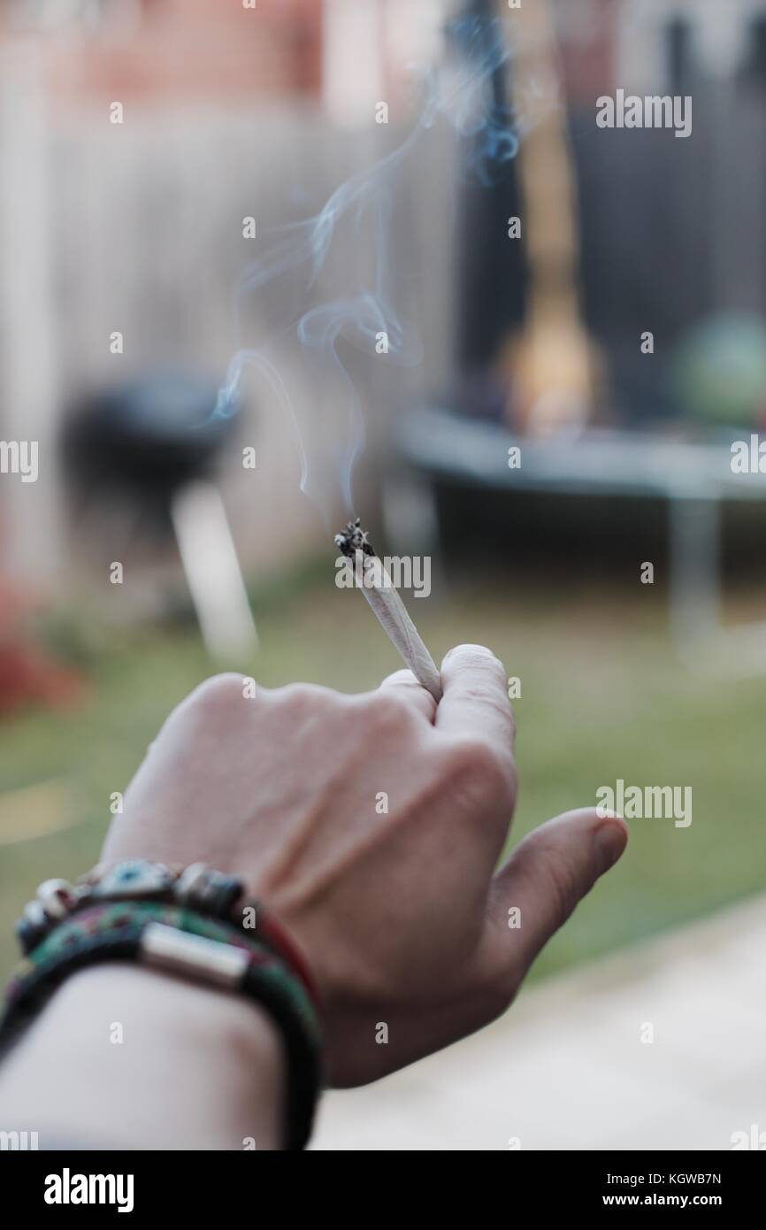 Small spliff in man hand. Marijuana smoking concept Stock Photo - Alamy